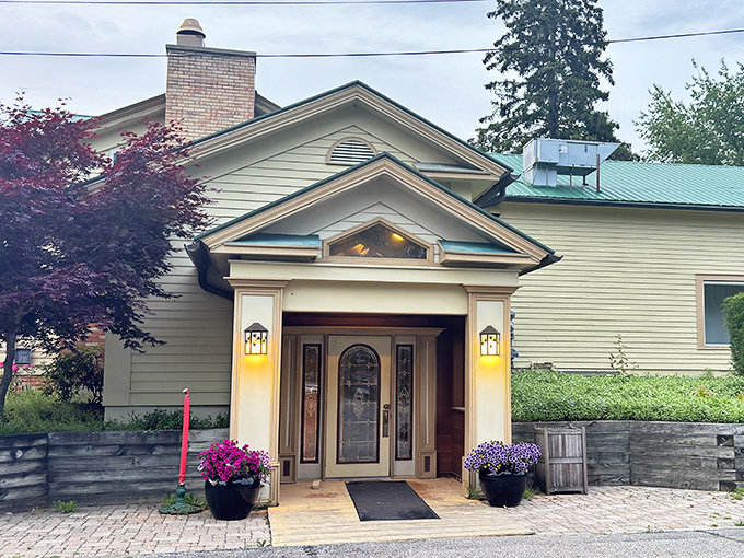 The charming farmhouse exterior of The Grill House welcomes you like an old friend, complete with colorful flower pots that say "come on in, the prime rib's waiting."