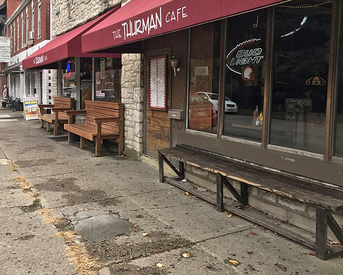 The unassuming storefront of Thurman Cafe, where culinary legends are born behind that modest red awning and wooden benches.