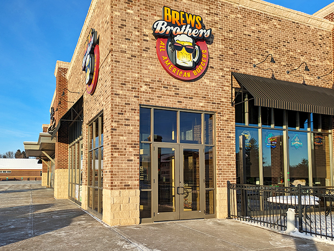 The brick fortress of flavor stands proud against the blue sky, its sunglasses-wearing beer mug logo promising good times within these hallowed walls.
