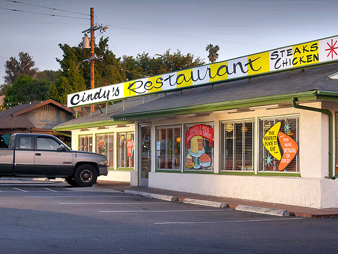 The iconic slanted yellow sign of Cindy's Restaurant stands as a beacon of hope for hungry Angelenos seeking authentic diner perfection.
