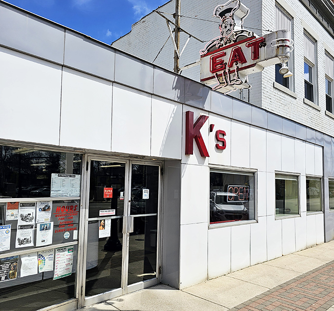 The iconic white-tiled exterior of K's Hamburger Shop stands as a beacon of culinary constancy in downtown Troy since 1935. That neon chef knows what's up. 