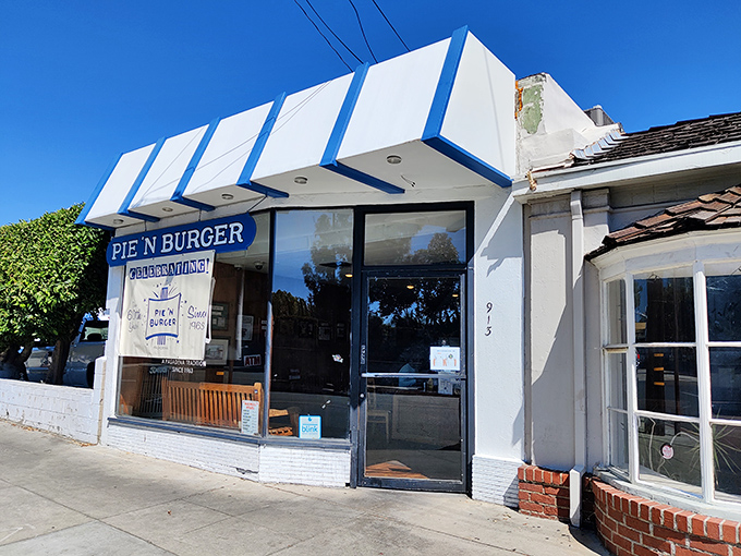 The iconic blue-and-white awning of Pie 'n Burger stands as a beacon of culinary constancy in Pasadena, promising the same delicious experience your taste buds remember.