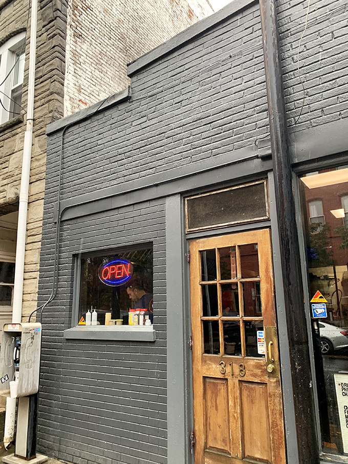 The unassuming gray brick exterior of Speed's with its wooden door marked "313" proves that culinary treasures often hide in plain sight.