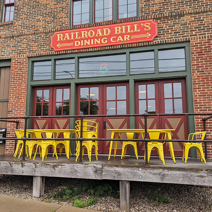 The bold red signage against rustic brick promises culinary adventures ahead, while those sunny yellow chairs practically beg you to sit and stay awhile.