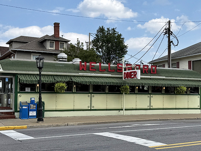 The Wellsboro Diner stands proudly on Main Street, its vintage railcar design and iconic red lettering a beacon for hungry travelers seeking authentic Americana.