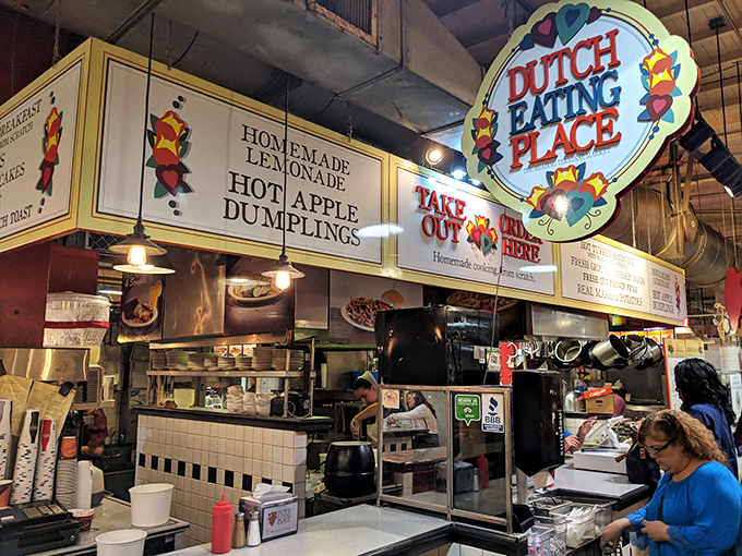 The colorful heart-adorned sign promises comfort before you've taken a single bite. Like a beacon of homestyle cooking amid market chaos.