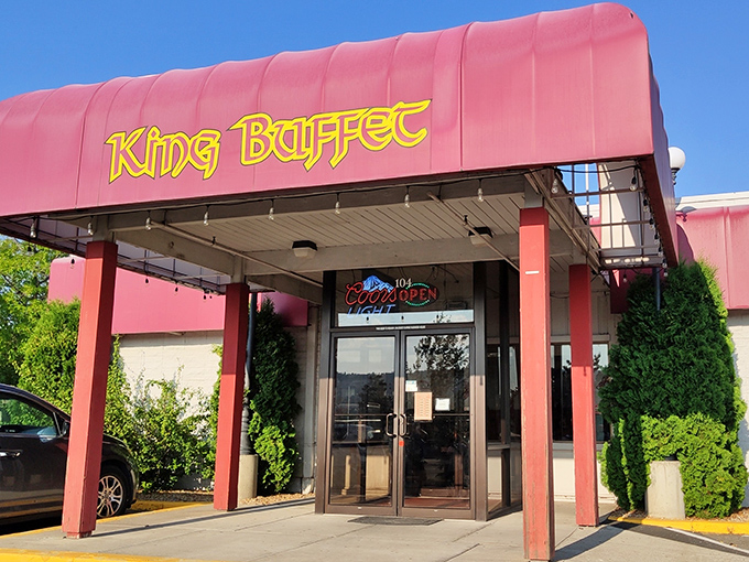 The pink awning and bold yellow lettering of King Buffet beckon like a neon promise of culinary abundance waiting just beyond those glass doors.