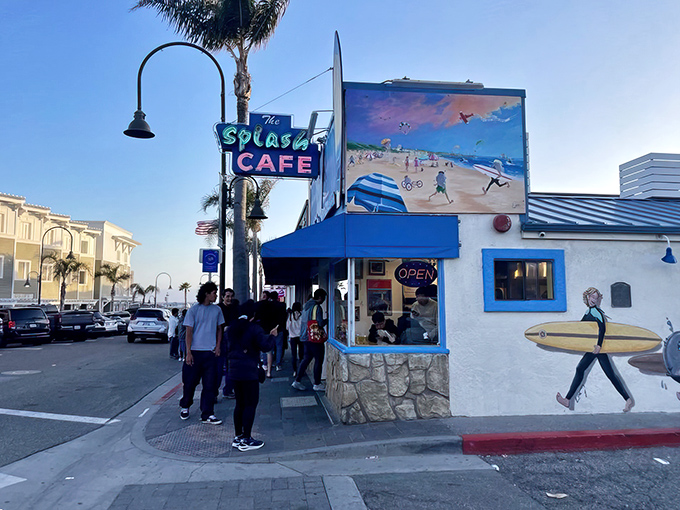 The iconic blue-trimmed exterior of Splash Caf&eacute;, where beach-themed murals and perpetual lines of hungry pilgrims signal you've arrived at chowder paradise.