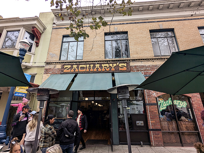 The brick facade of Zachary's beckons hungry patrons with its forest-green awnings, while the line forming outside suggests breakfast treasures worth waiting for.