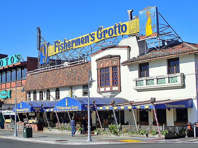 The iconic blue-and-gold sign of Old Fisherman's Grotto stands like a maritime beacon, promising seafood treasures within those Spanish-style walls.