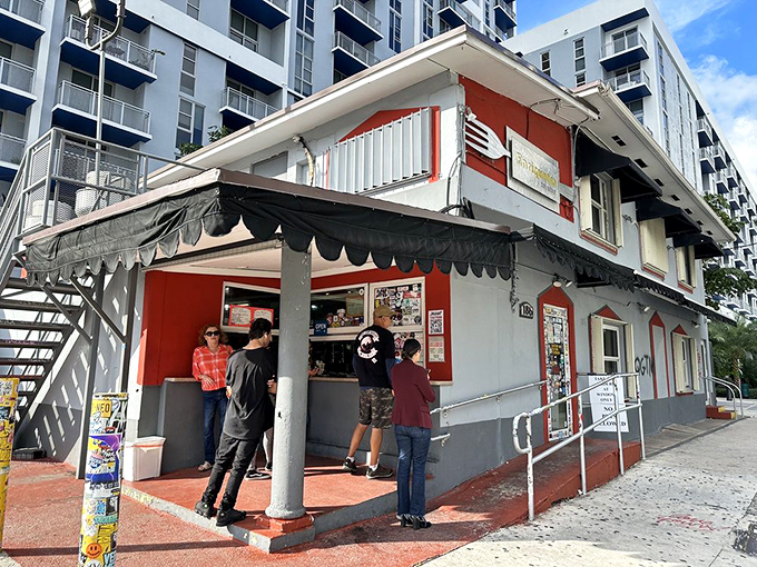 The humble red and white exterior of Enriqueta's stands defiant against Miami's glass towers, like a culinary David facing an army of architectural Goliaths.