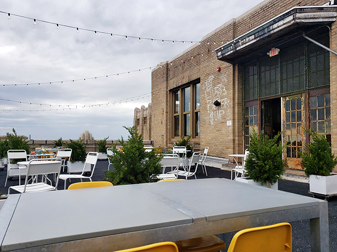 String lights and potted greenery transform this industrial rooftop into an urban oasis where South Philly meets Sicily under open skies.