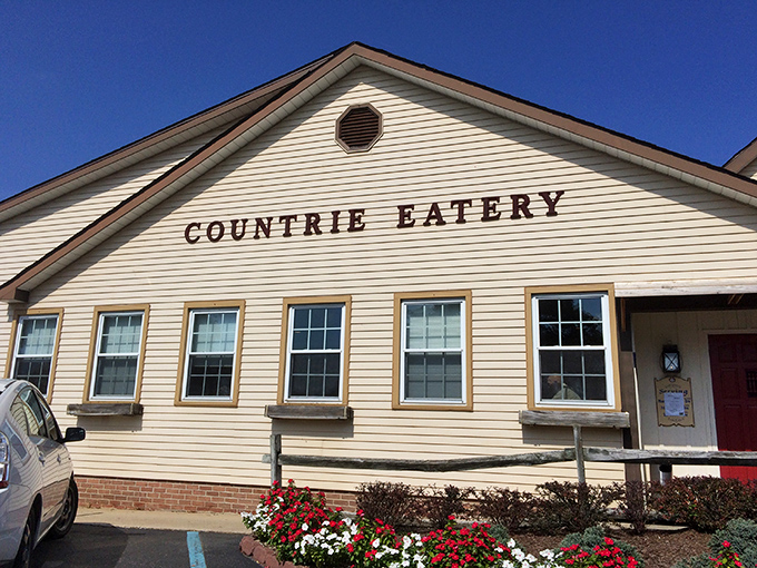 The cream-colored exterior of The Countrie Eatery stands proudly against a blue Delaware sky, promising homestyle comfort before you even step inside.
