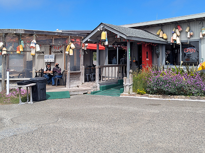 The weathered charm of The Boat House beckons like an old friend, colorful buoys dangling like maritime jewelry against the rustic wooden exterior.