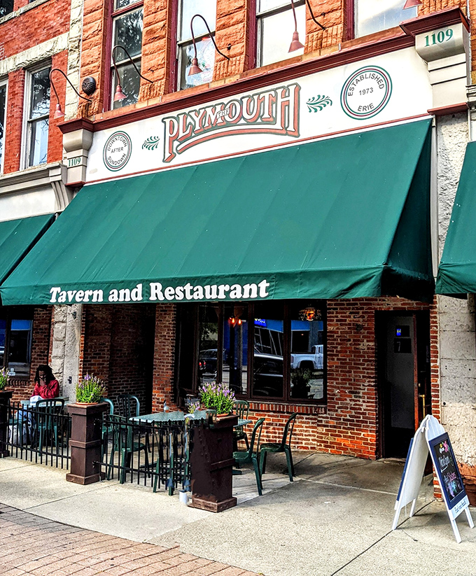 The iconic green awning of Plymouth Tavern stands as Erie's culinary lighthouse, beckoning hungry travelers with the promise of comfort and community.