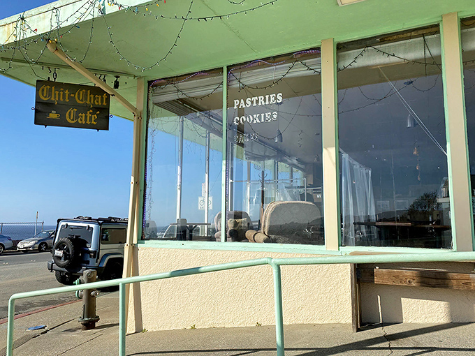 Morning light streams through windows framing the Pacific, while the cafe's weathered sign promises pastries and conversation in equal measure.