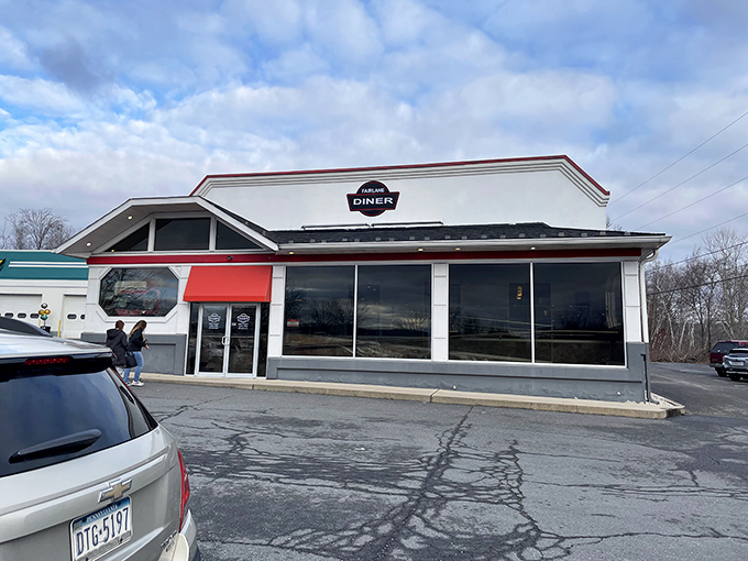 The unassuming exterior of Fairlane Diner stands like a humble superhero of breakfast, its powers hidden behind modest white walls and red trim.