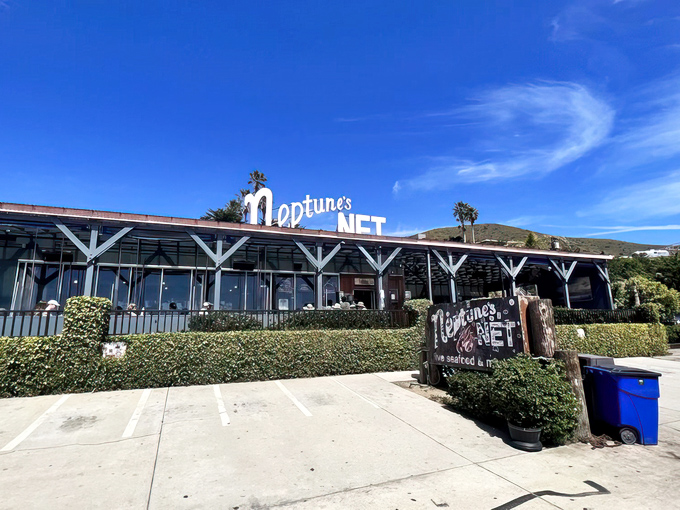Neptune's Net stands proudly along PCH, its weathered blue exterior and iconic sign beckoning road-trippers like a siren call to seafood paradise.