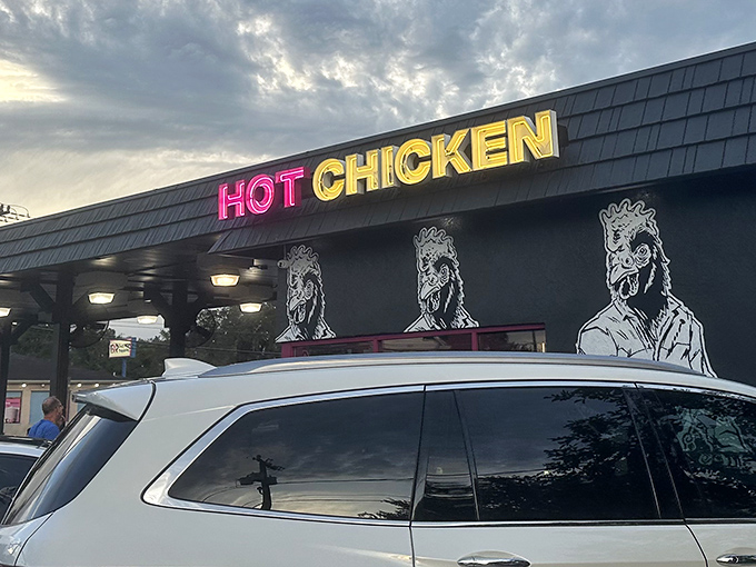 The neon "HOT CHICKEN" sign glows like a beacon of delicious promise against the sleek black exterior. Pink accents hint at the flavor explosion waiting inside.