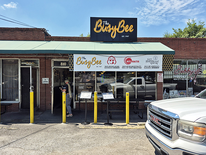 The unassuming brick exterior of Busy Bee Cafe hides Atlanta's soul food treasure. Yellow bollards stand guard like sentinels protecting culinary gold.