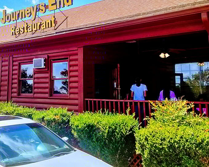 The rustic log cabin exterior of Journey's End beckons like an old friend, promising comfort food and Southern hospitality beneath that iconic yellow sign.