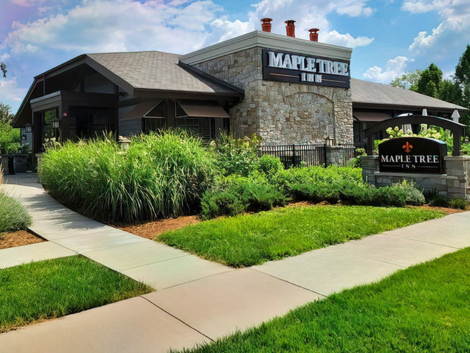 The stone facade of Maple Tree Inn stands like a culinary fortress, promising Cajun treasures within its walls.