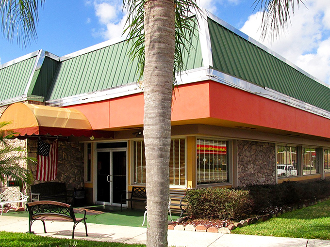 The coral-colored exterior with its distinctive green roof stands as a beacon of breakfast hope for hungry travelers along Central Florida's highways.