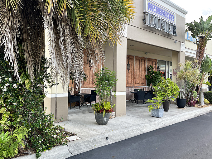 Palm trees frame the entrance to Time Square Diner like nature's own welcome committee, offering a shady respite from the Florida sun.