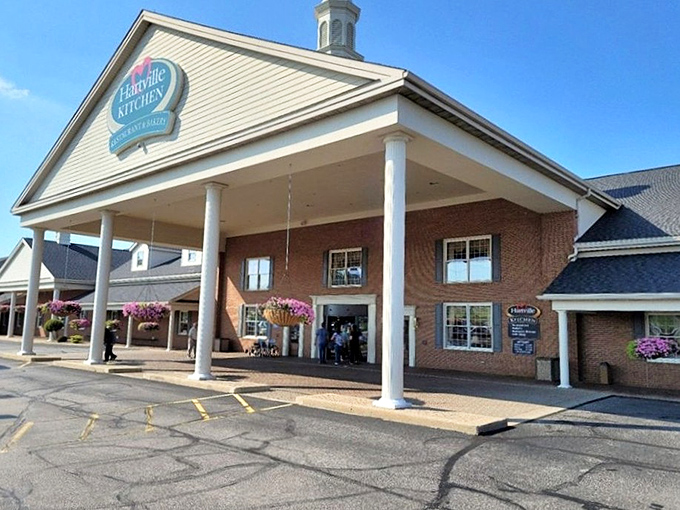 The welcoming facade of Hartville Kitchen stands proudly with its white columns and hanging flower baskets, like a culinary embassy of comfort food.