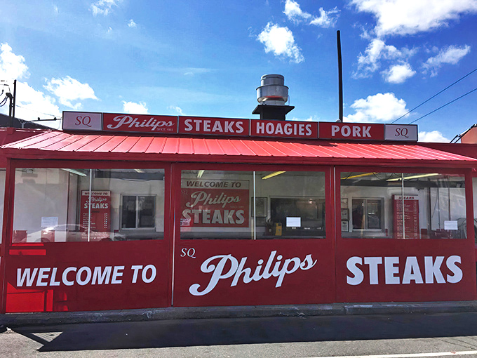 The iconic red and white checkerboard exterior of SQ Philip's Steaks stands as a beacon of hope for hungry Philadelphians seeking sandwich salvation.