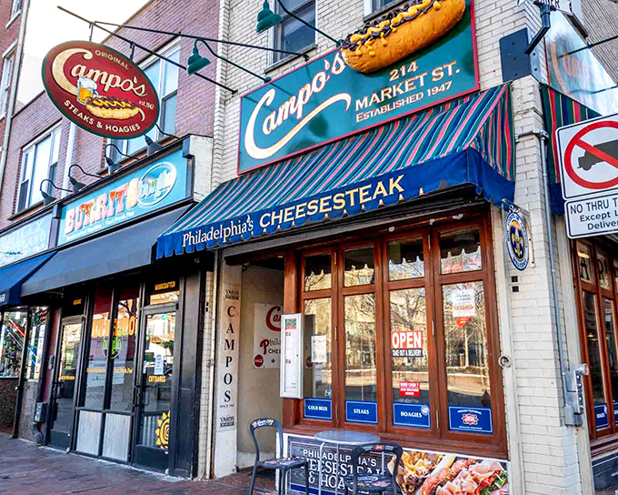 Campo's iconic blue awning and vintage signage stand as a beacon of sandwich perfection in Philadelphia's historic district, promising authentic cheesesteak bliss since 1947.