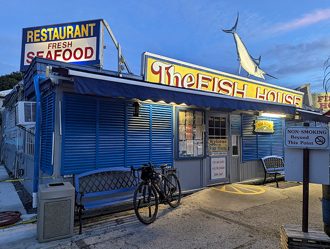 The blue corrugated exterior of The Fish House stands like a maritime mirage in Key Largo, complete with that iconic marlin silhouette promising seafood treasures within.
