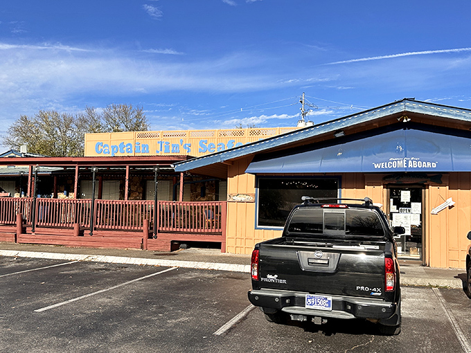 The unassuming exterior of Captain Jim's Seafood Buffet beckons seafood lovers with its blue sign and welcoming wooden deck&mdash;proof that culinary treasures often hide in plain sight.
