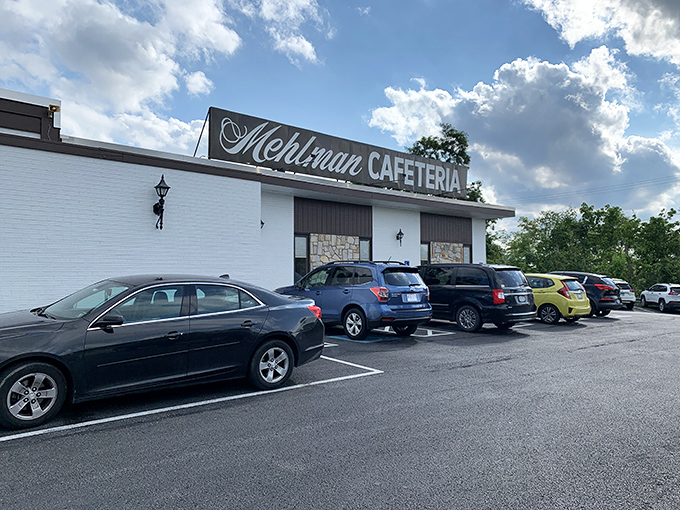 The unassuming exterior of Mehlman's Cafeteria stands like a culinary time capsule, promising comfort food treasures that have kept cars filling this parking lot for generations.