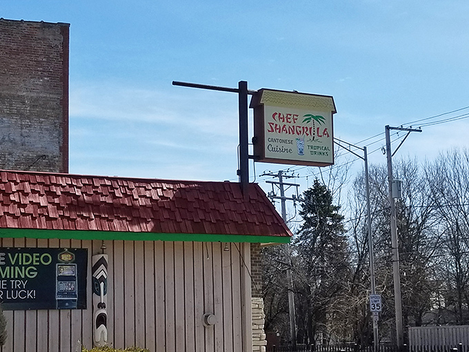 Don't judge this tiki paradise by its humble exterior. That blue Adirondack chair is basically saying, "Slow down, friend, culinary magic happens inside."