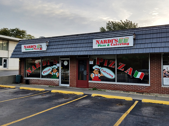 The unassuming storefront that houses pizza greatness. Blue shingled roof, red brick, and Italian flag colors promise authentic flavors inside.