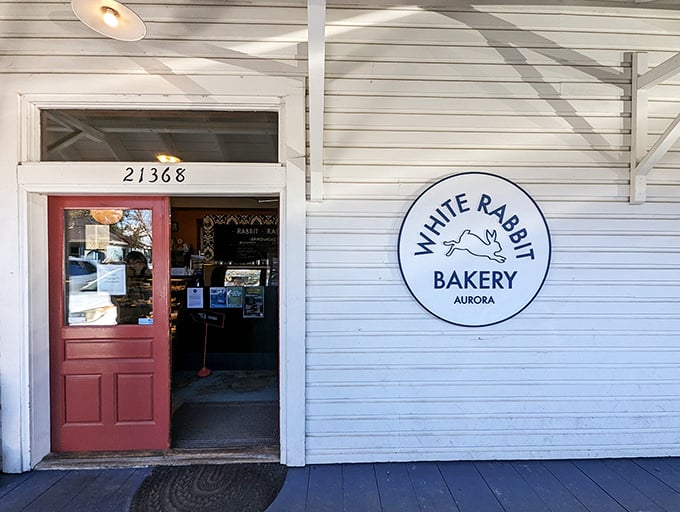 The unassuming white exterior with its cheerful red door is like a storybook cottage that happens to house pastry perfection instead of woodland creatures.