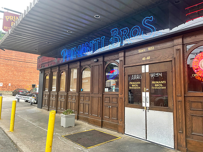 The iconic blue neon sign of Primanti Bros. glows like a beacon in Pittsburgh's Strip District, promising sandwich salvation to hungry pilgrims.