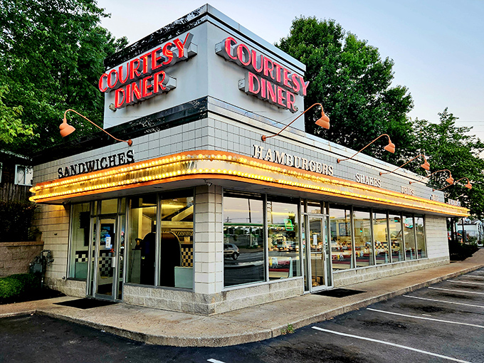 The neon-lit promise of Courtesy Diner glows against the twilight sky, a beacon for hungry souls seeking comfort food salvation in St. Louis.