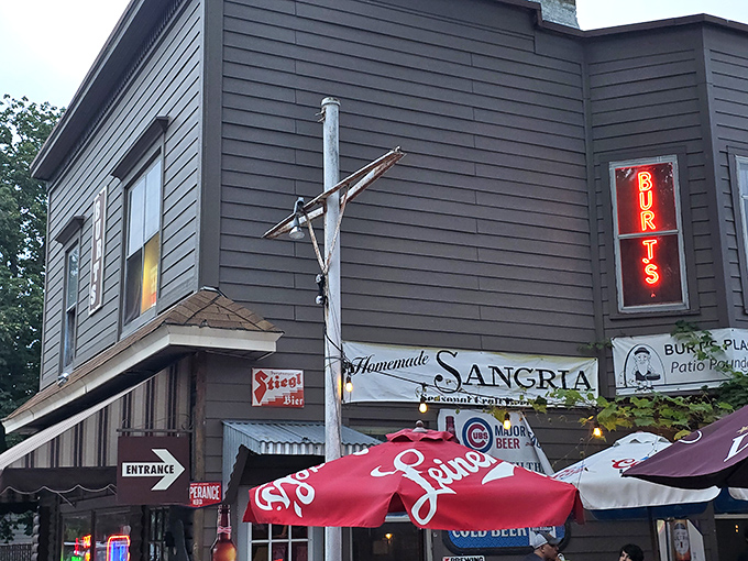 The unassuming gray exterior of Burt's Place, with its vintage neon sign, proves that pizza paradise often hides in plain sight.