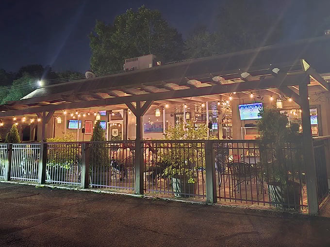 Twilight transforms this Akron patio into an urban oasis. String lights twinkle overhead like stars, promising memorable meals under the wooden pergola.