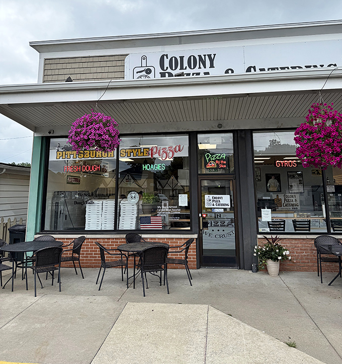 The unassuming storefront of Colony Pizza, where hanging flower baskets add a touch of charm to this Erie culinary treasure hiding in plain sight.