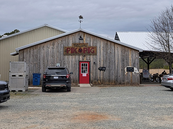 Rustic charm meets serious barbecue at Pik N Pig's weathered wooden exterior. That red door isn't just an entrance&mdash;it's a portal to smoke-infused happiness.