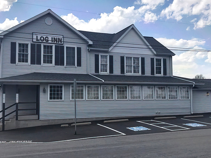 The Log Inn stands proudly against an Indiana sky, its white clapboard exterior hiding the culinary treasures within. This unassuming building houses chicken worth crossing county lines for.