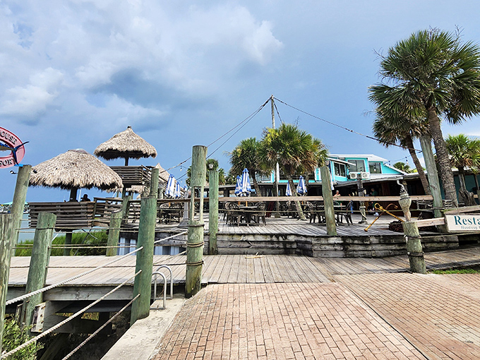 The entrance to paradise isn't pearly gates, but a wooden boardwalk leading to thatched huts where seafood dreams and waterfront views become reality.