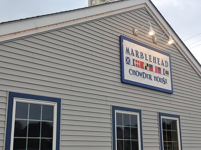 Colorful nautical flags adorn the Marblehead sign, a silent promise of maritime delights within. Those little lights aren't just for show&mdash;they're guiding you to chowder nirvana.