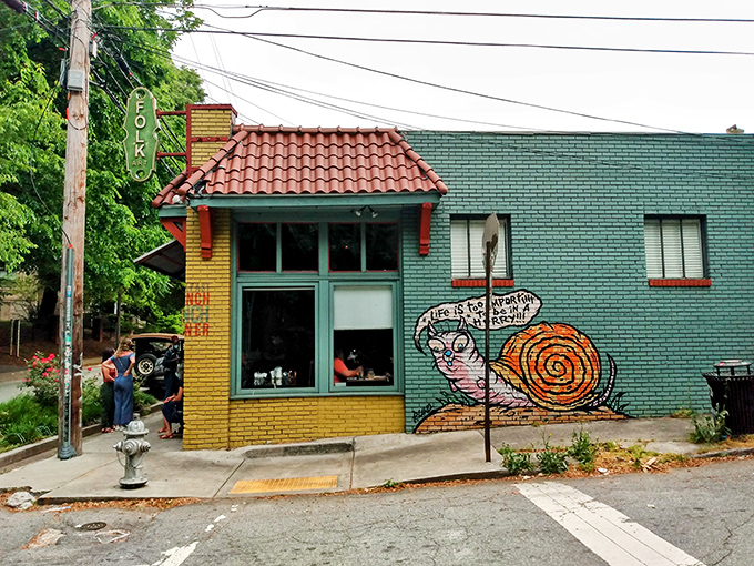 The teal and yellow exterior of Folk Art stands out like a culinary beacon, complete with a whimsical snail mural that seems to whisper, "Good things come to those who wait."