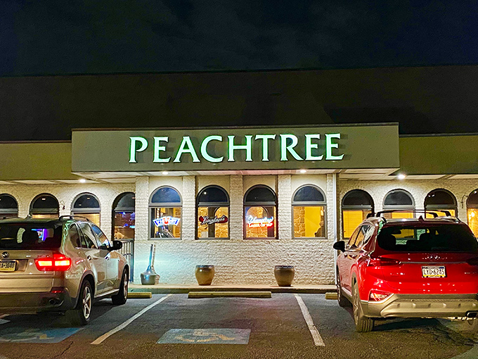 The glowing Peachtree sign beckons like a lighthouse for hungry souls. Even at night, this unassuming strip mall gem promises culinary treasures within.