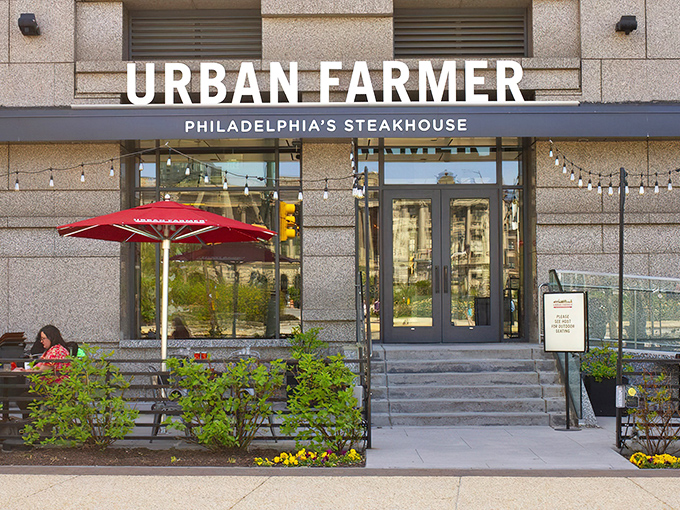 The sleek exterior of Urban Farmer Philadelphia promises modern sophistication while string lights hint at the warm welcome waiting inside.