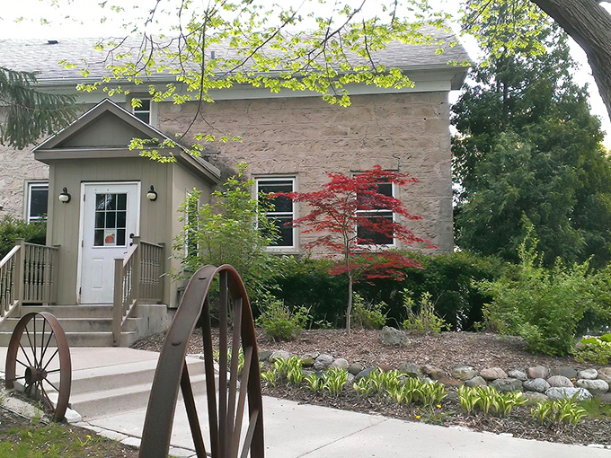 The historic stone exterior of The Farmstead welcomes you with rustic charm, complete with a wagon wheel entrance that whispers, "Slow down, good food takes time."